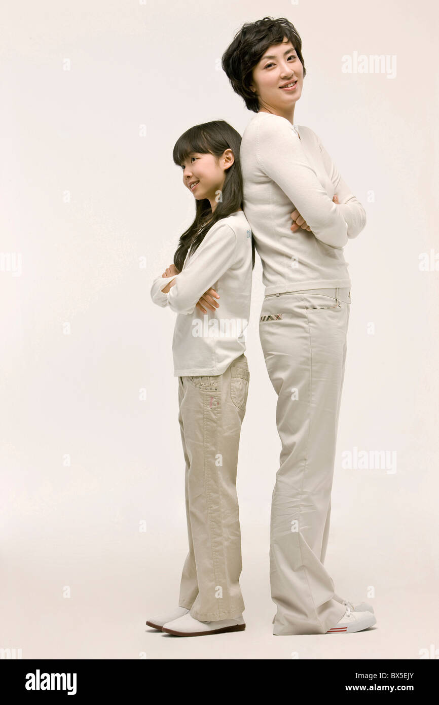 Mother and daughter standing back to back Stock Photo - Alamy