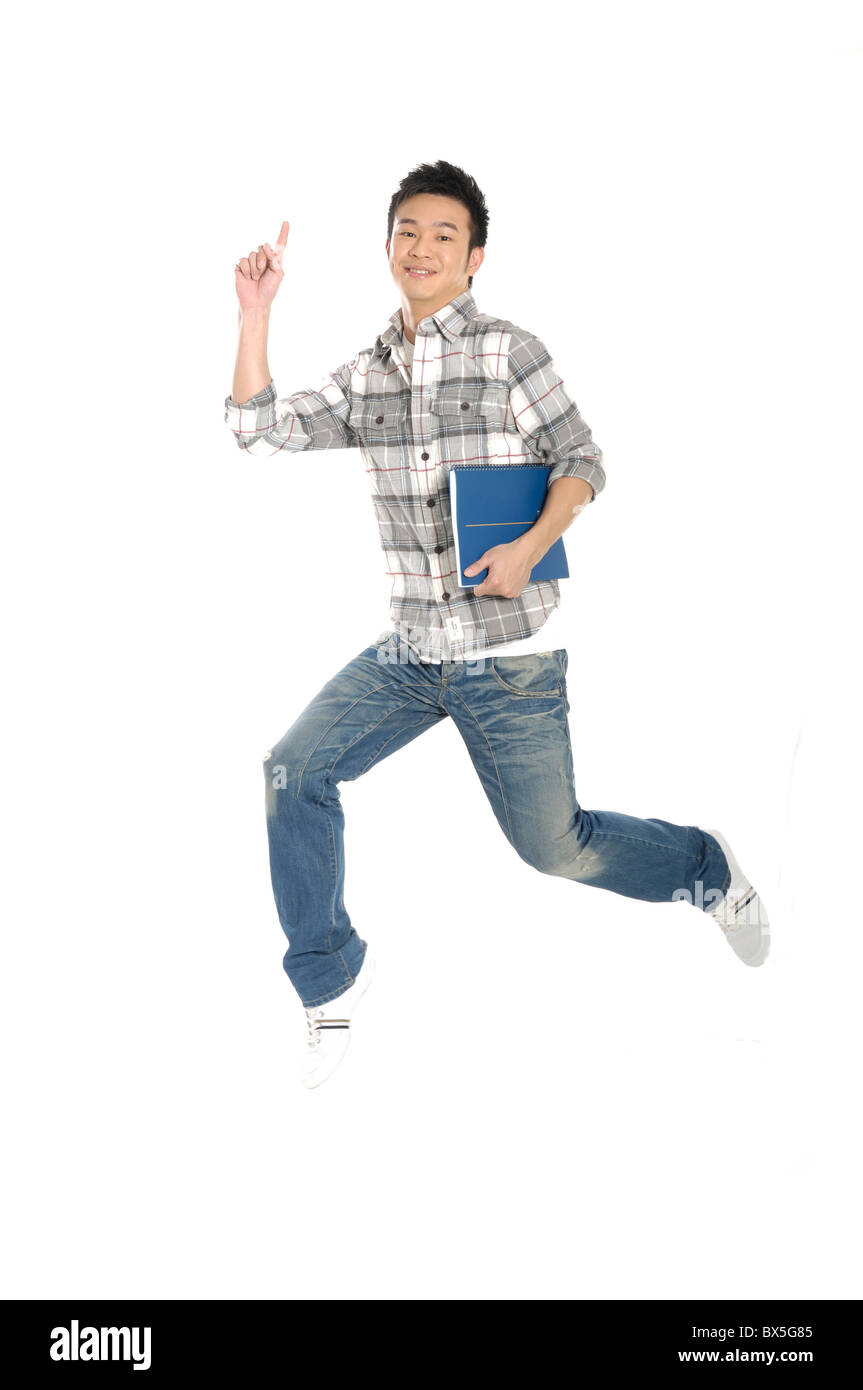 Male university student pointing upward and jumping Stock Photo - Alamy