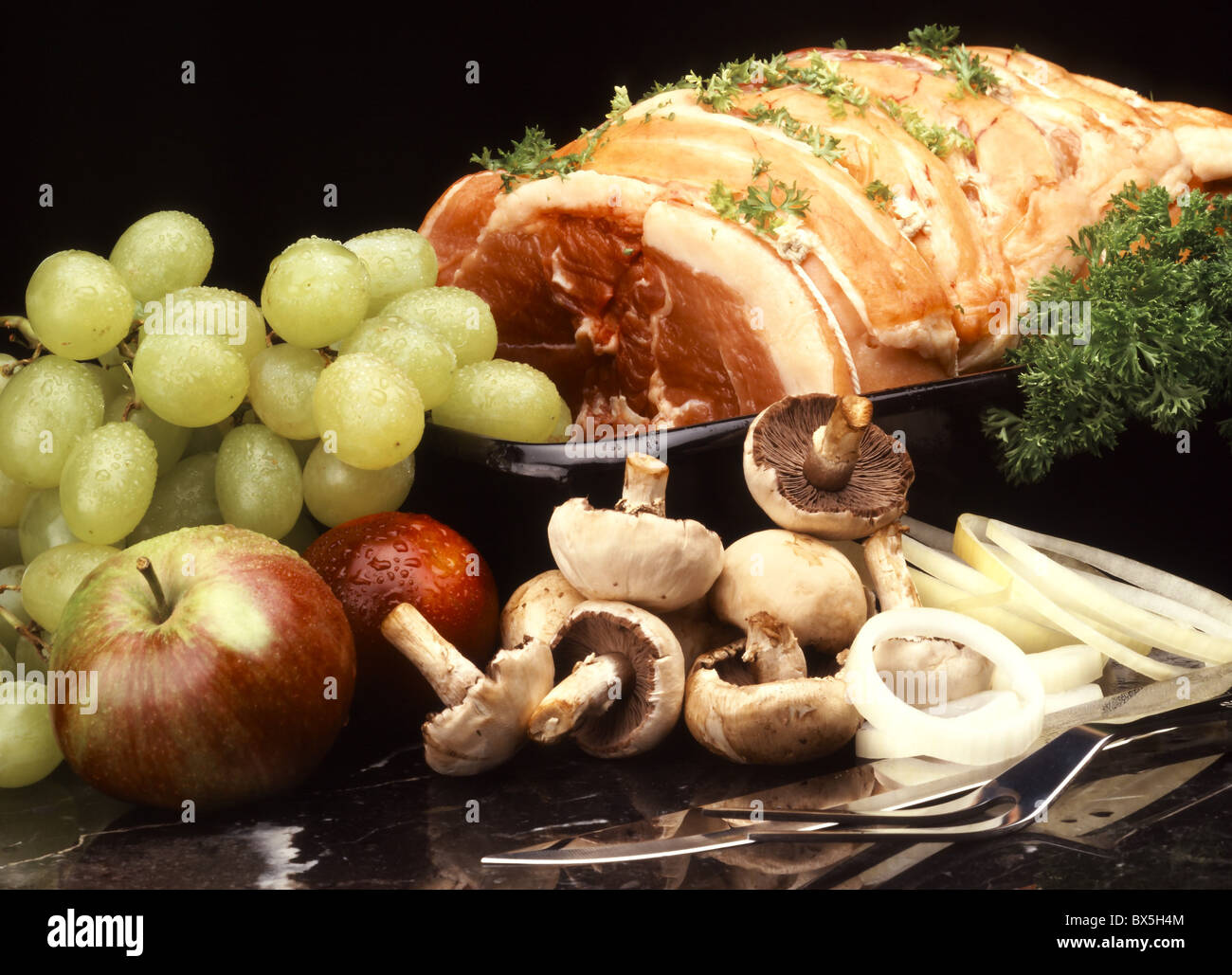 Fresh pork and fruit display with apple, grapes,mushroom Stock Photo ...