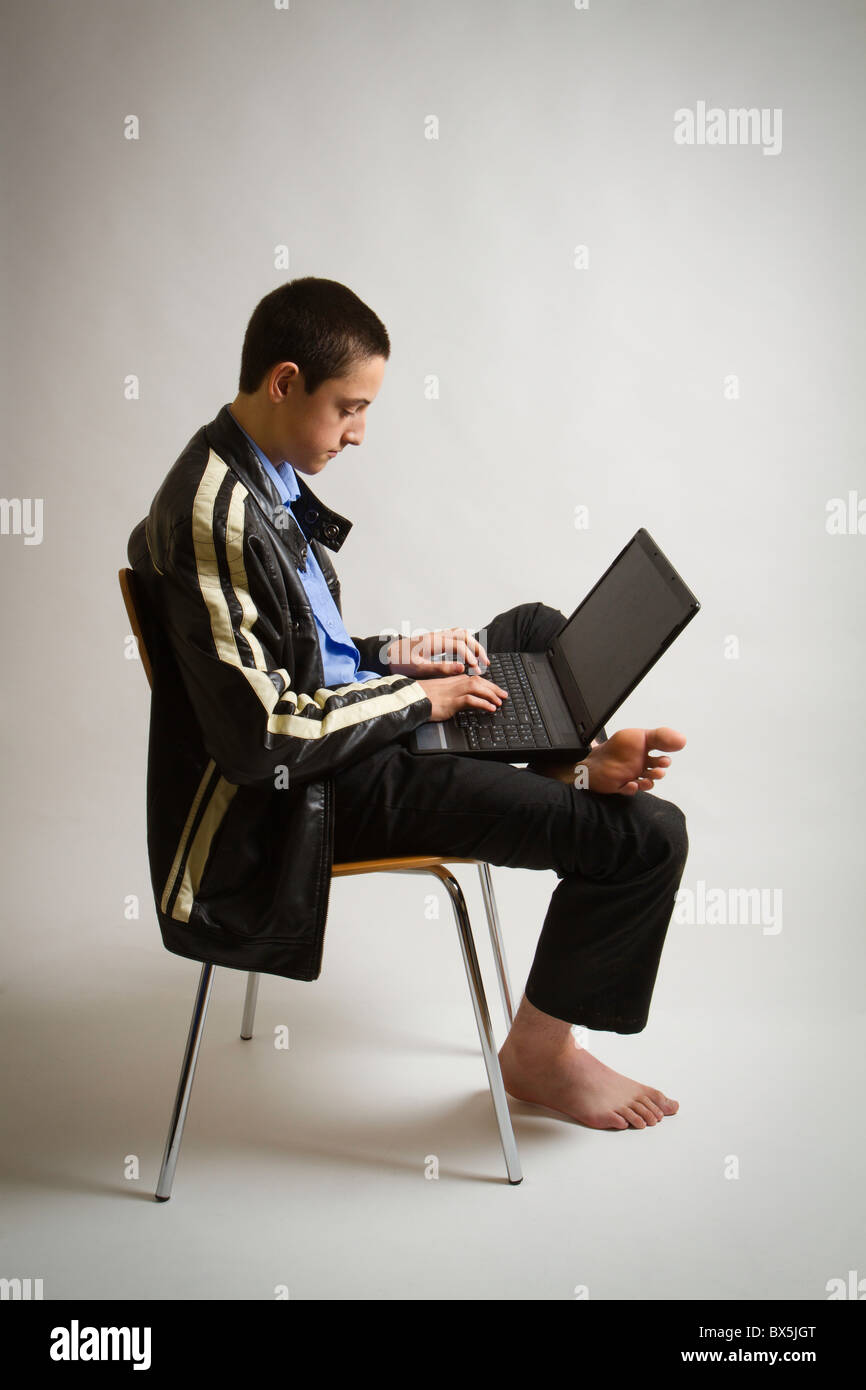 Teenage boy with laptop from the "Computer for Every Child" program ...