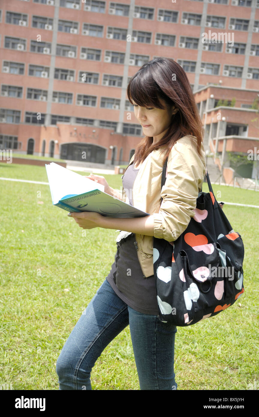 Female university student reading a book Stock Photo - Alamy