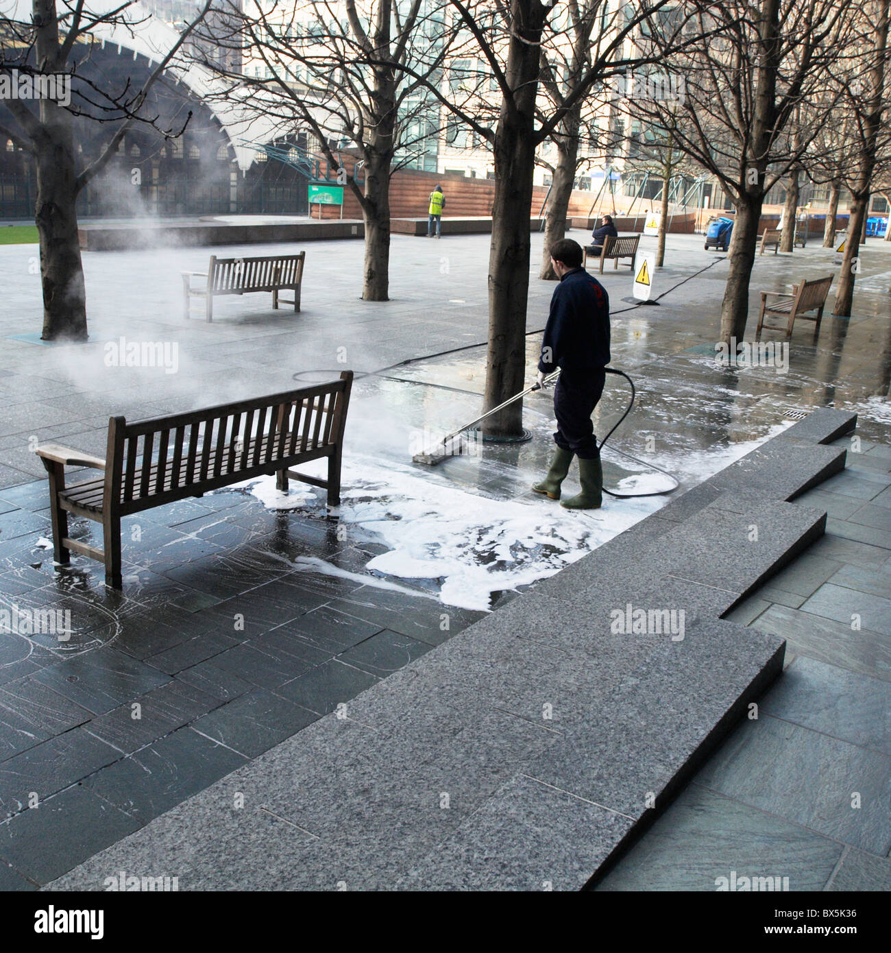 Street cleaner using power wash to clean pavement Liverpool St London ...