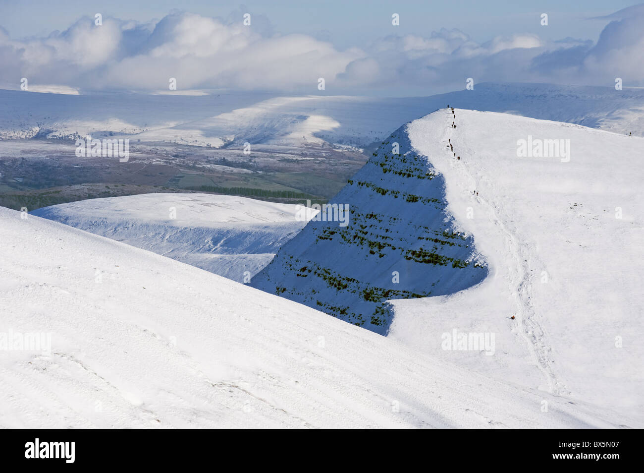 Hikers on snow covered Pen y Fan mountain, Brecon Beacons National Park ...