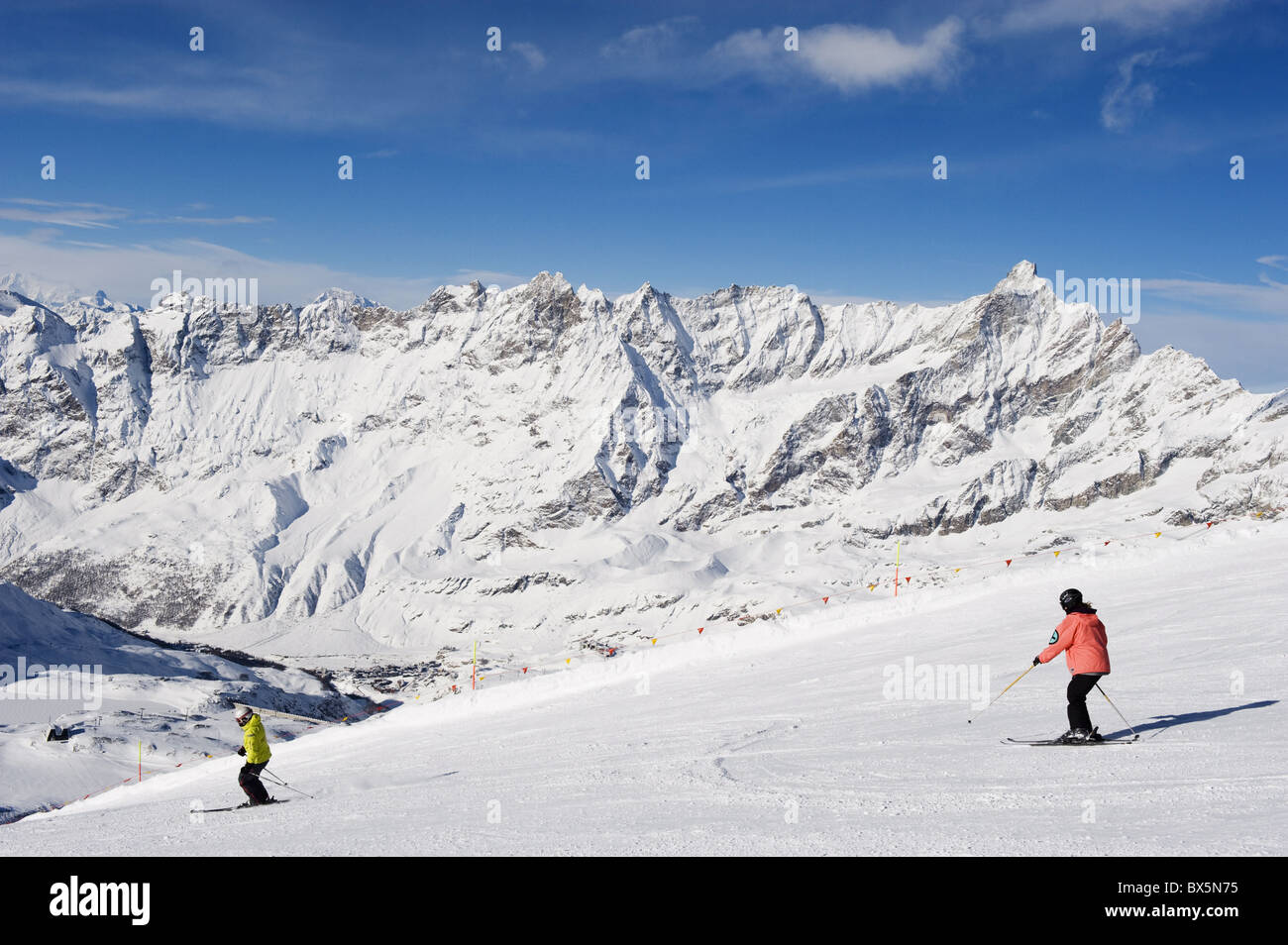 Skiers skiing on a ski run, mountain scenery in Cervinia ski resort ...