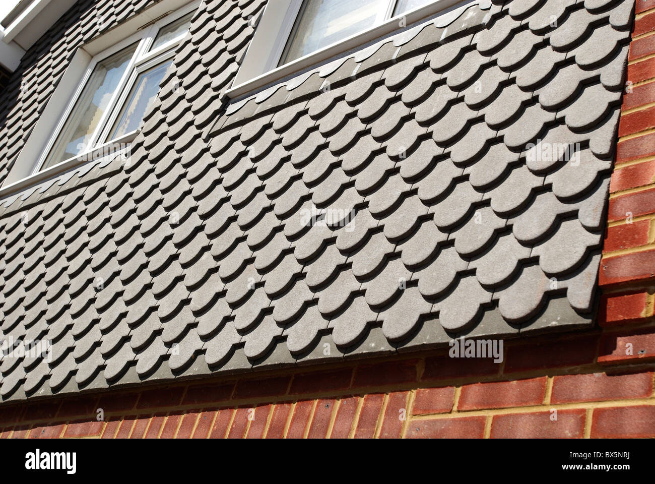 Weather proofing tiles on a house Stock Photo - Alamy