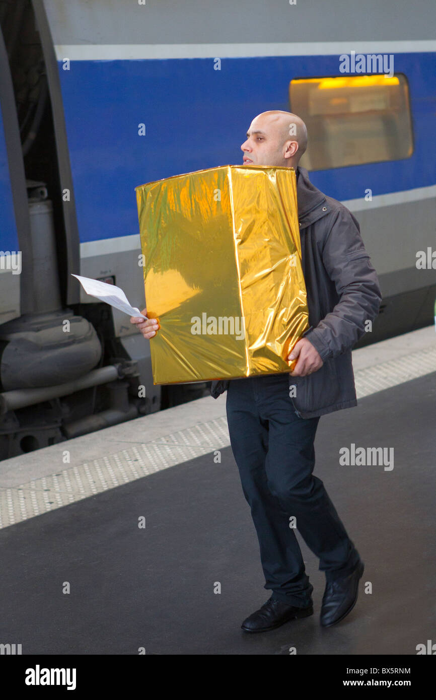 man carrying gold box Stock Photo - Alamy