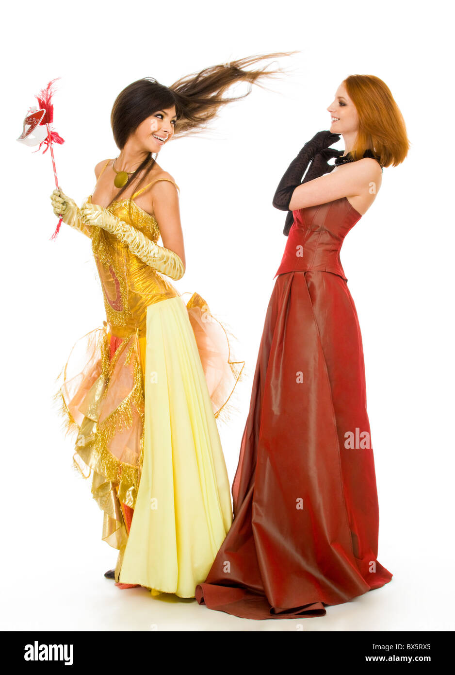 Photo of joyful actresses in fashionable dresses having fun over white ...