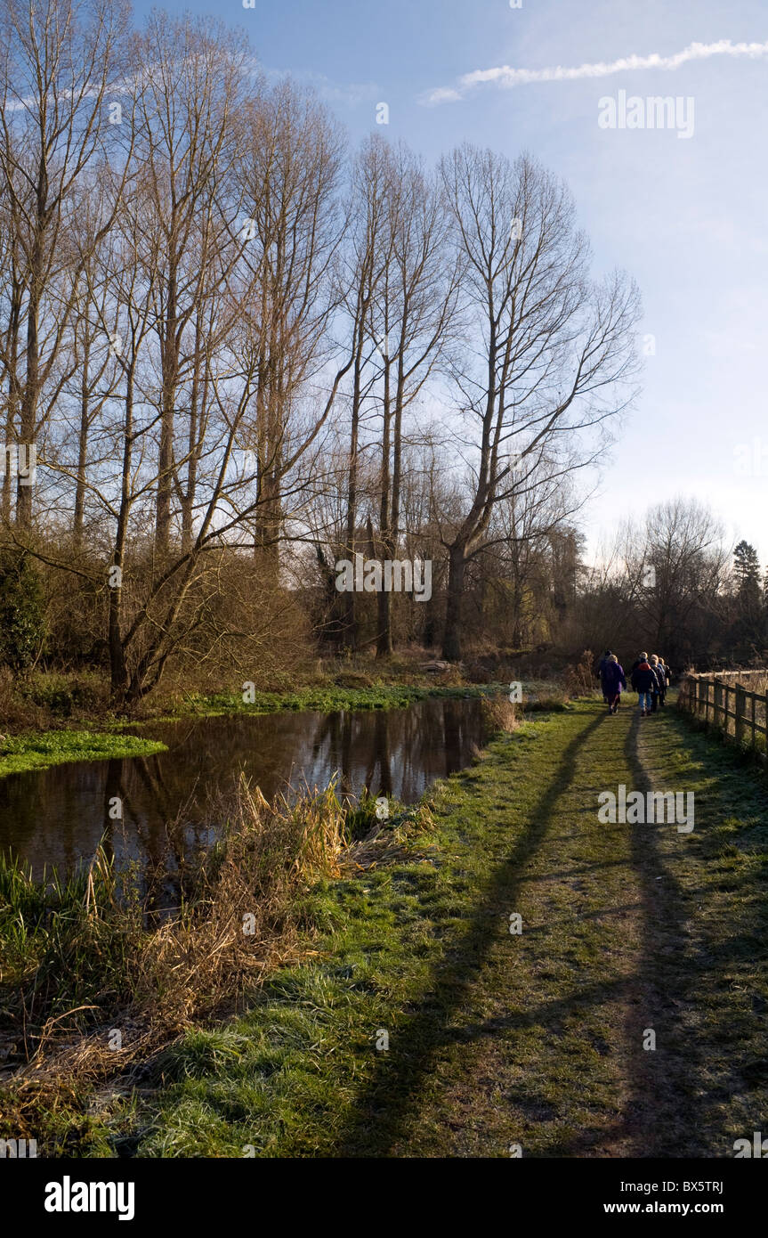 A Winter scene; Walkers and hikers in the distance along the banks of ...
