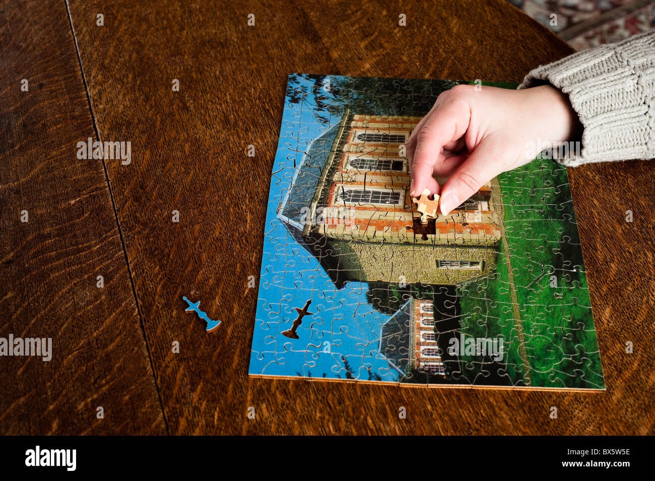 Man working on a Landmark Trust jigsaw puzzle of The Library, in Devon ...
