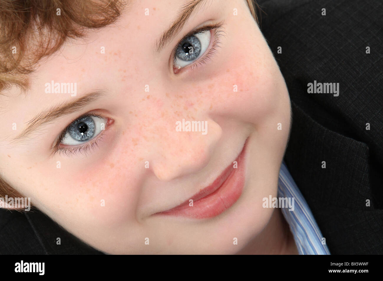 Attractive ten year old american boy in baggy blue suit over white ...