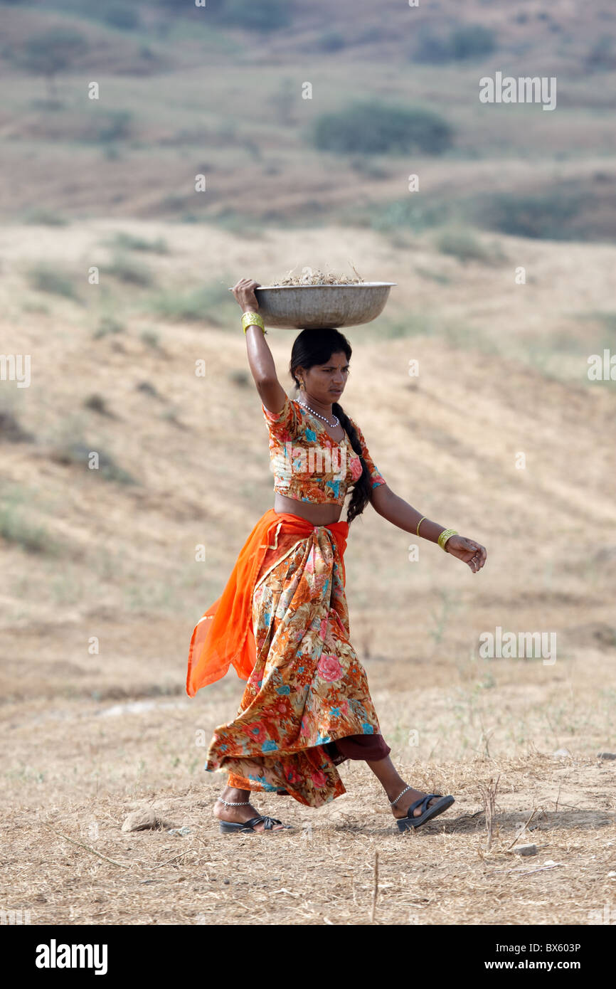 Indian woman carrying large pot on her head Stock Photo - Alamy