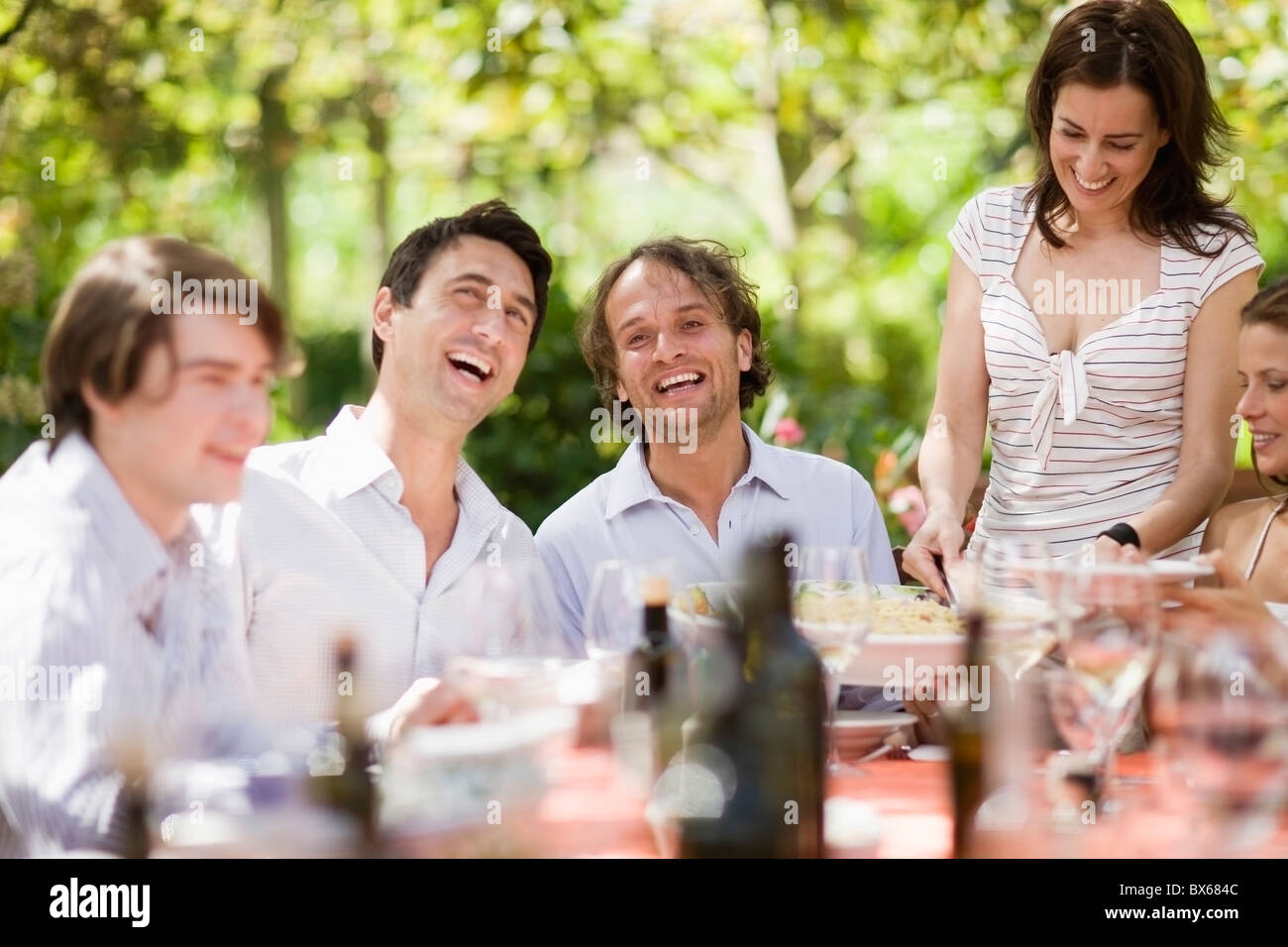 Laughing people sitting on a table Stock Photo - Alamy
