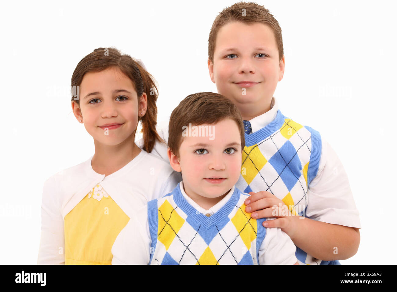 Two brothers and sister in matching outfits over white background Stock ...