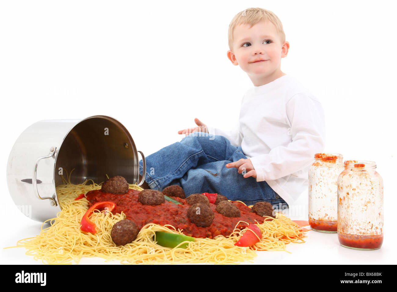Adorable 2 year old boy sitting in huge spaghetti mess over white floor ...