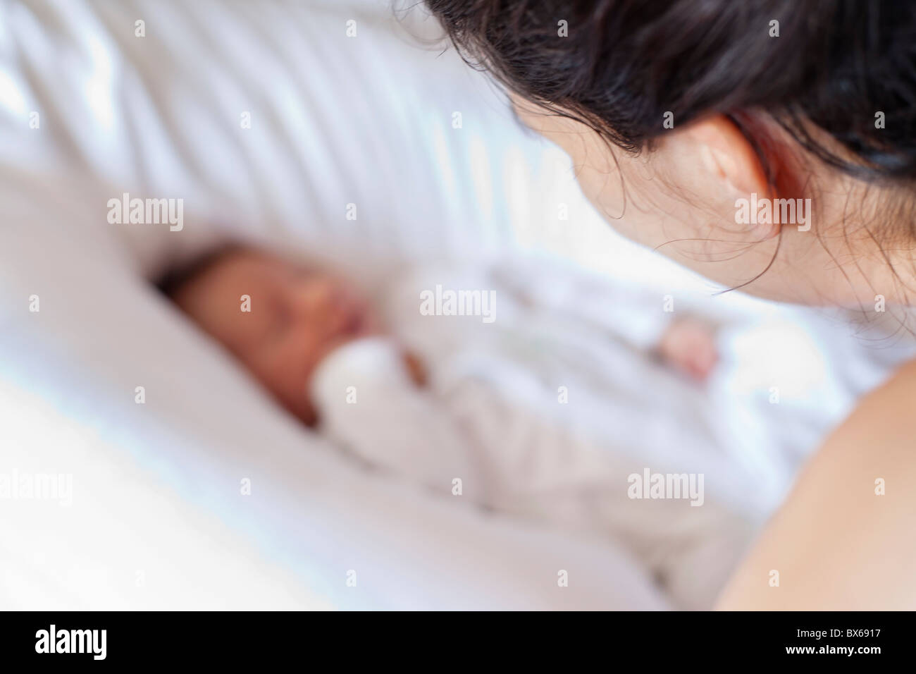 Mother watching over newborn baby Stock Photo - Alamy
