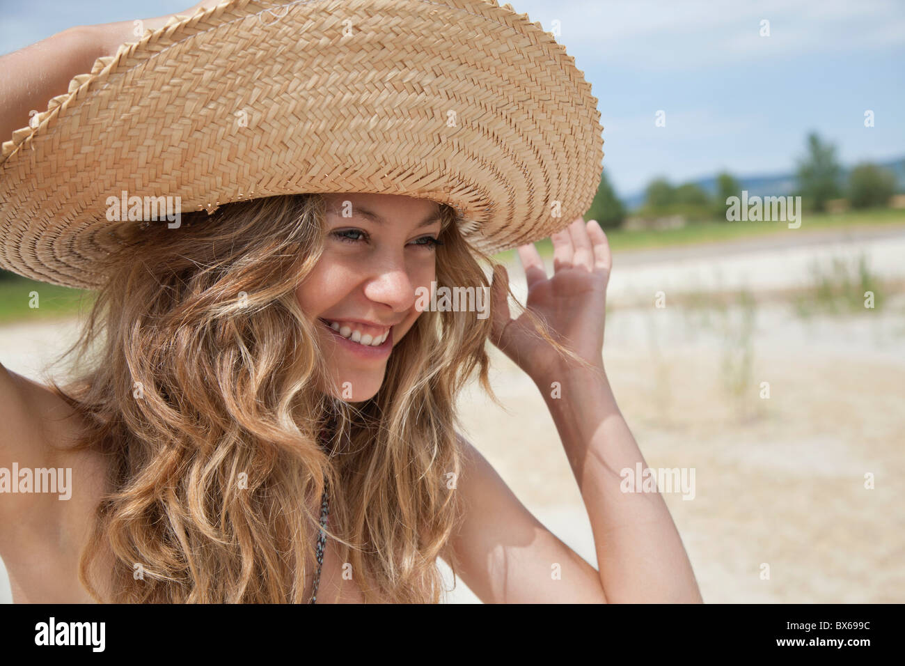 Pretty woman in straw hat laughing Stock Photo - Alamy