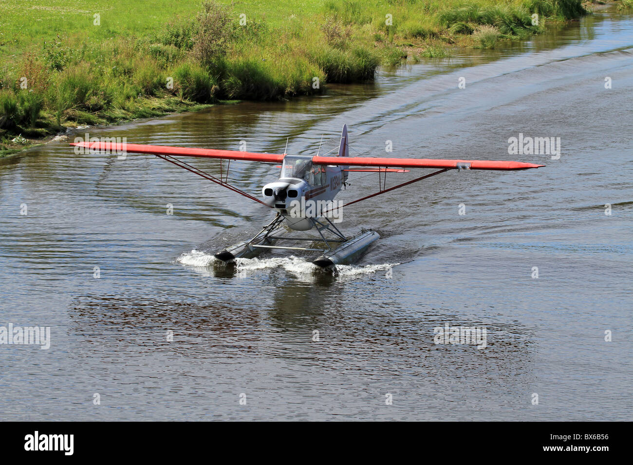 Float plane or seaplane taking flight to travel, fly on a river in ...