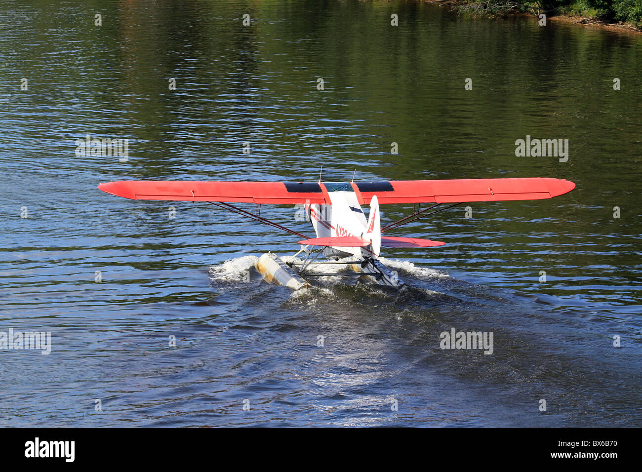 Float plane or seaplane taking flight to travel, fly on a river in ...