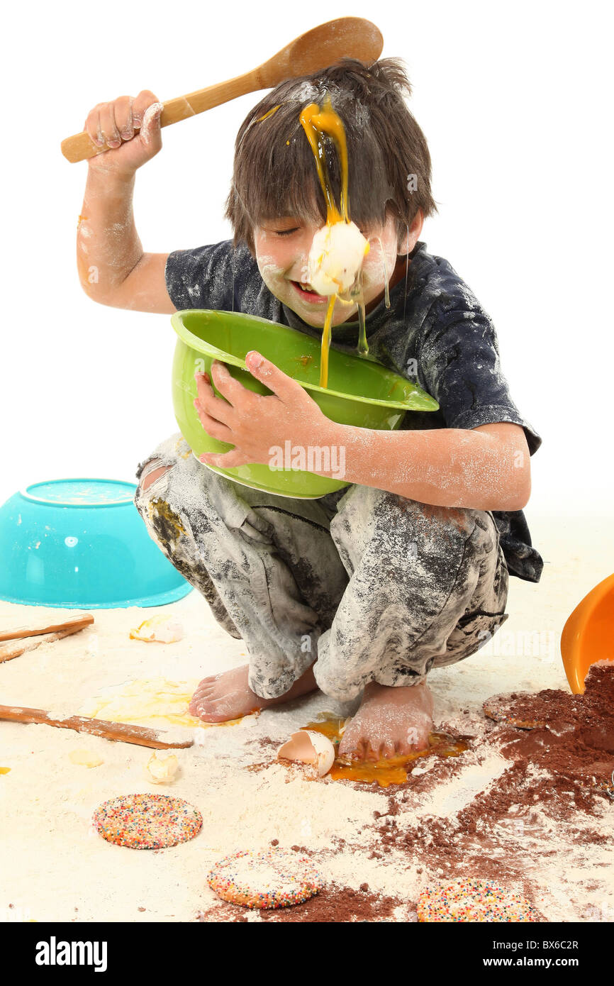 Adorable 7 year old french american boy making mess baking cookies ...
