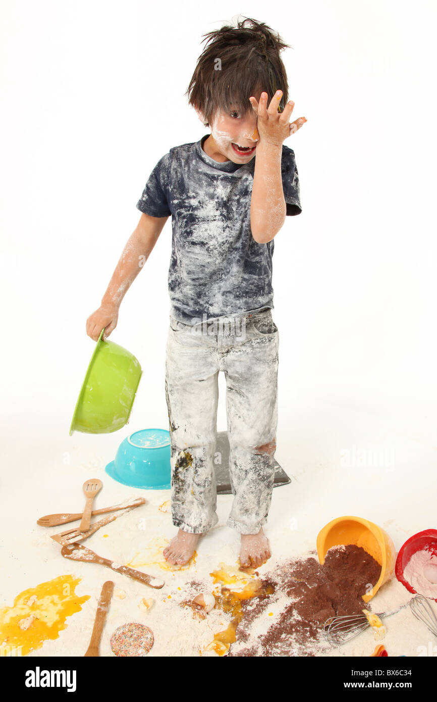 Adorable 7 year old french american boy making mess baking cookies ...