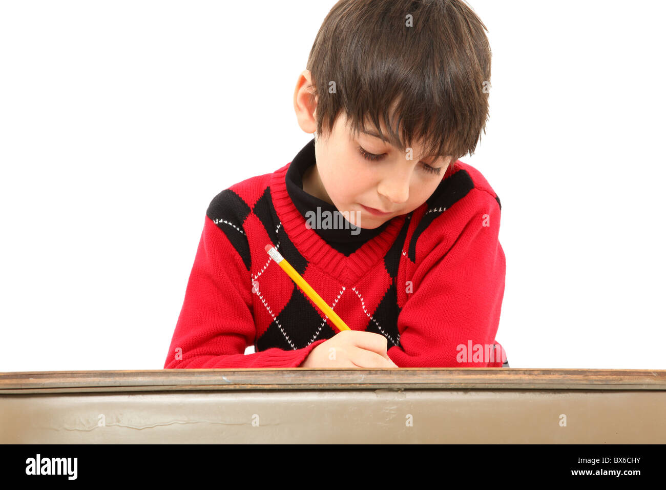 Attractive 7 year old french american boy in school desk over white ...