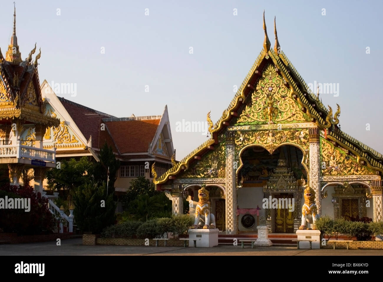 A beautiful gold Buddhist temple decorated with ornate designs is part ...