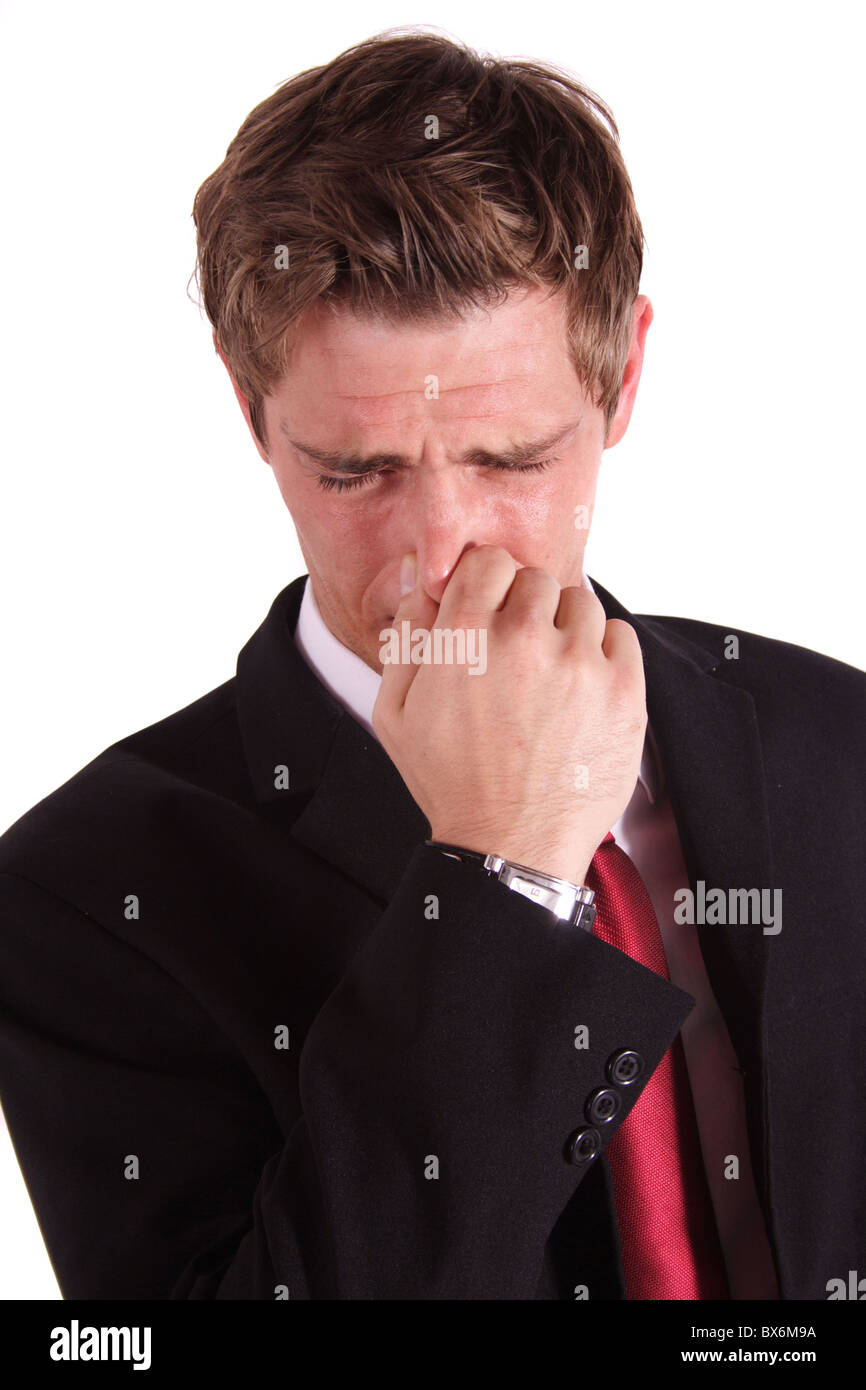A handsome businessman smells something stinky. All isolated on white ...