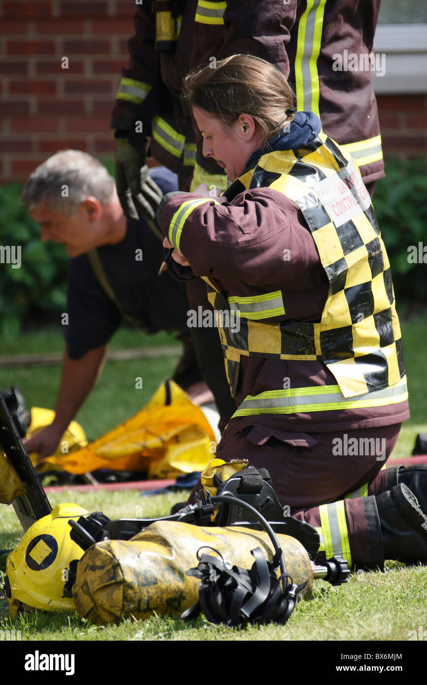 Fire crews servicing equipment at scene of fire Stock Photo - Alamy