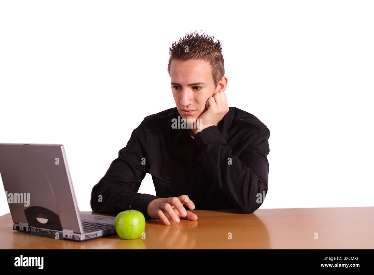 A young bored man is sitting at his workplace. All isolated on white ...