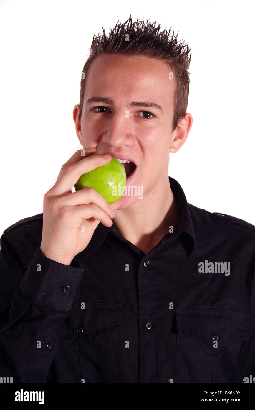 A young handsome man eating an apple. All isolated on white background ...