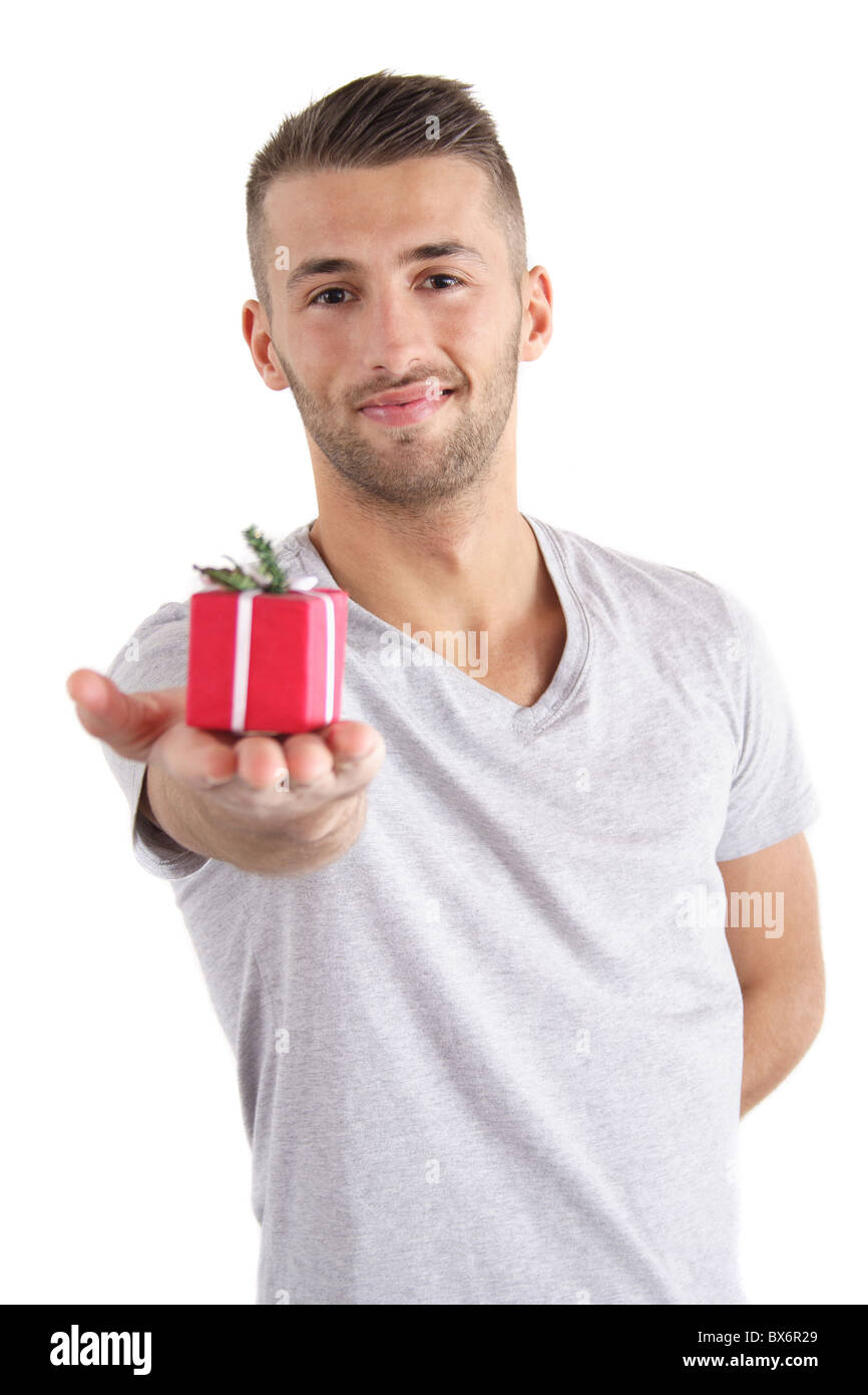 A handsome man holding a small red present. All isolated on white ...