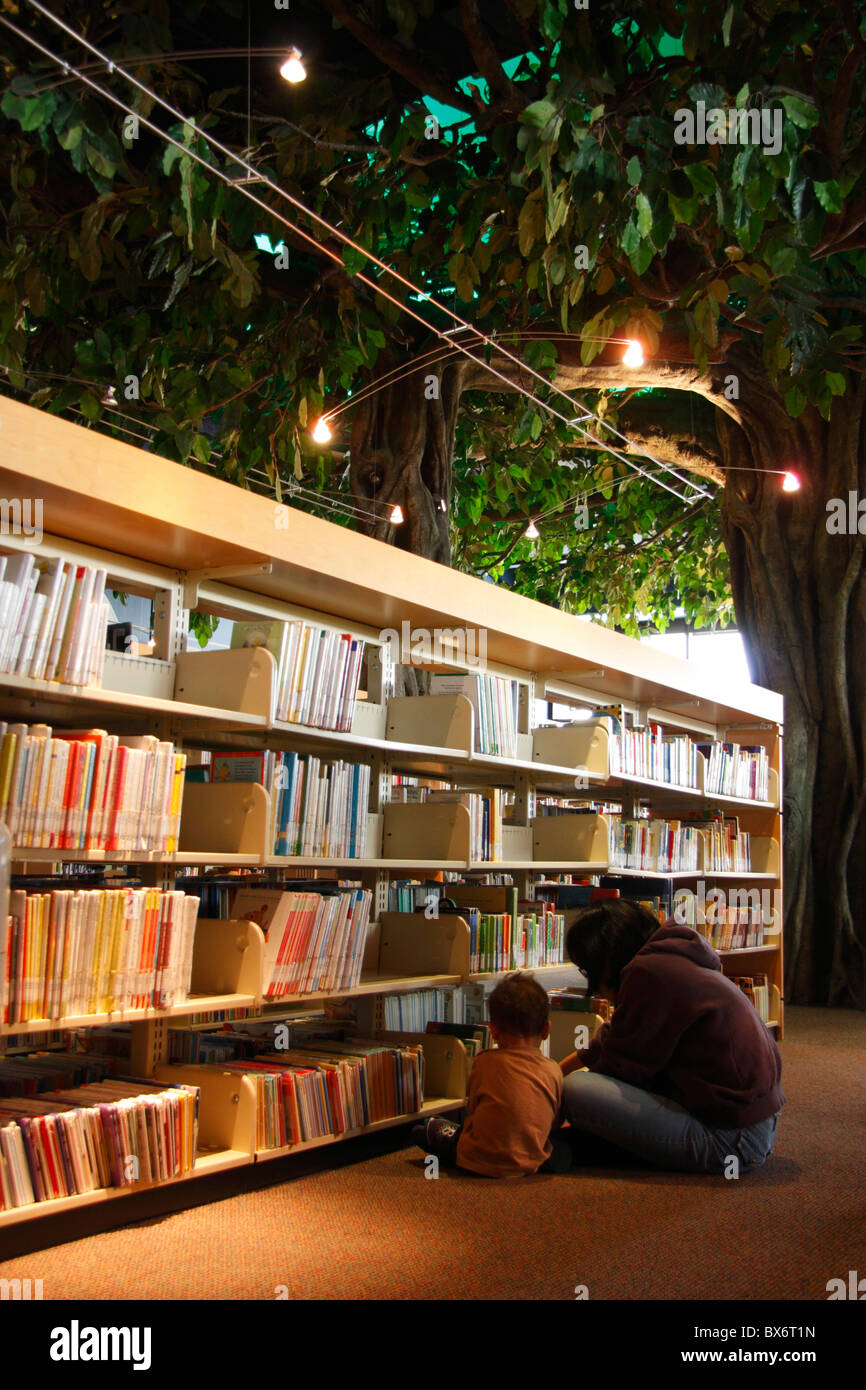A mother and her son read books in the children's library at the ...