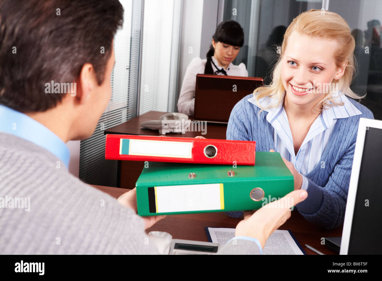 Pretty secretary giving papers to boss in the office Stock Photo - Alamy