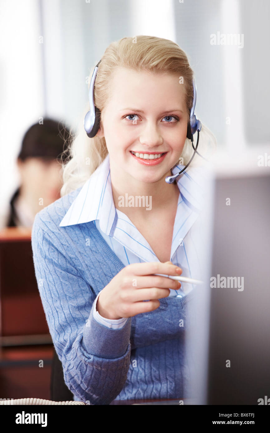 Pretty secretary speaking on headphone in the office Stock Photo - Alamy
