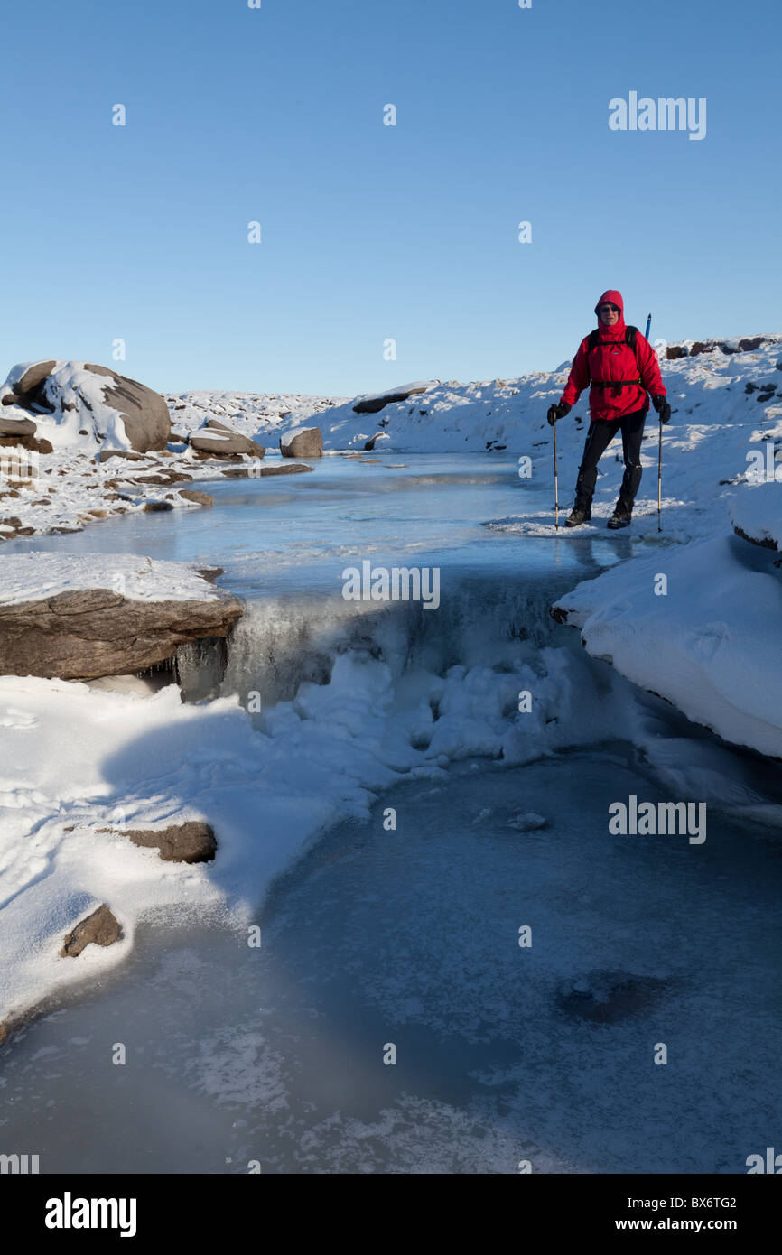 A walker on the frozen Kinder River, winter on Kinder Scout in the Dark ...