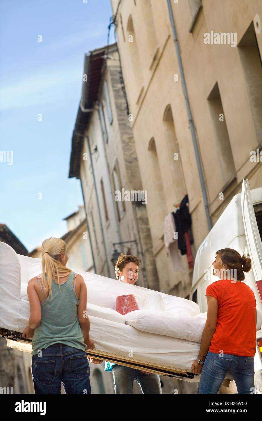 Friends move couch in street Stock Photo - Alamy