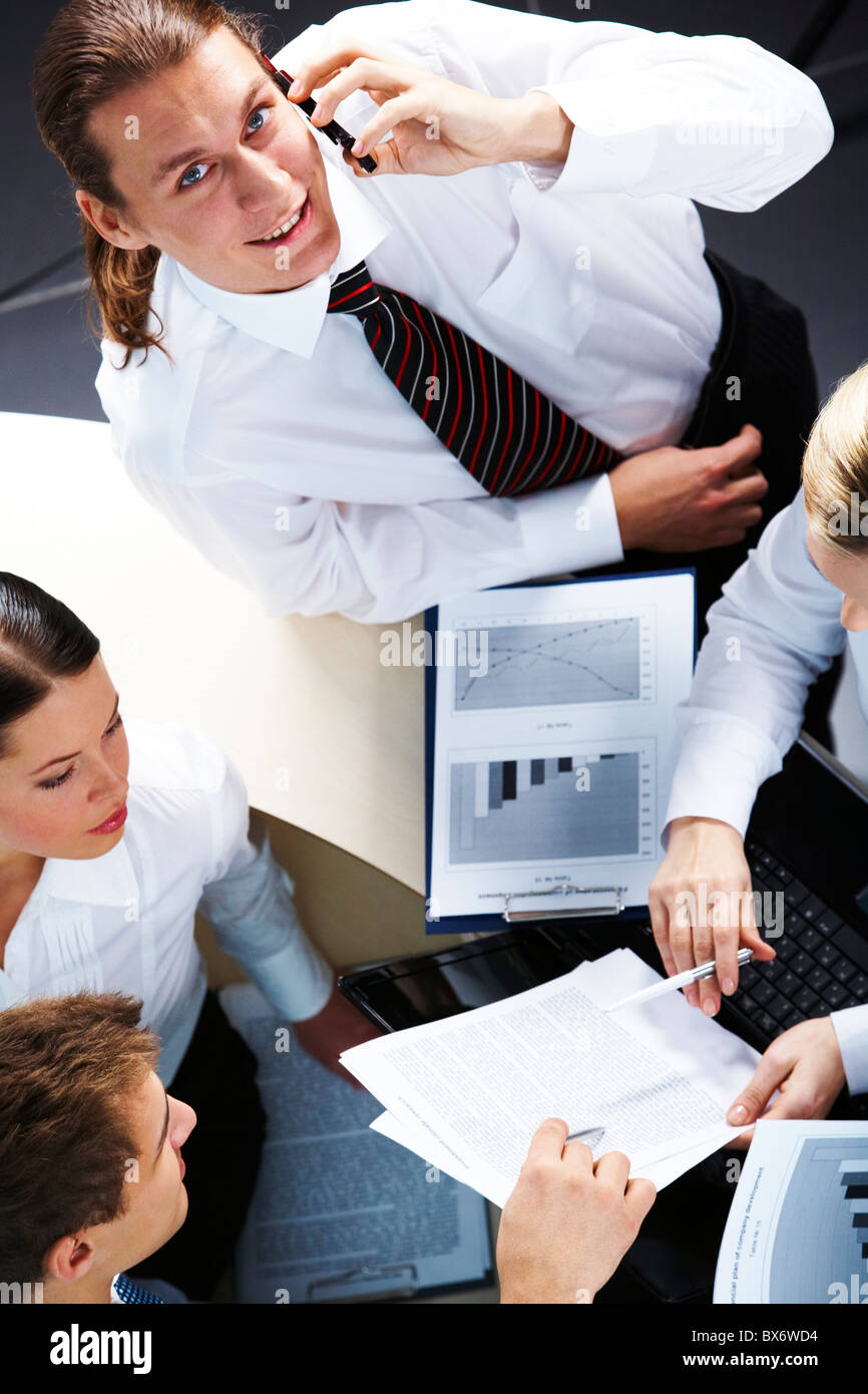 Above view of businessman looking at camera while speaking on the phone ...