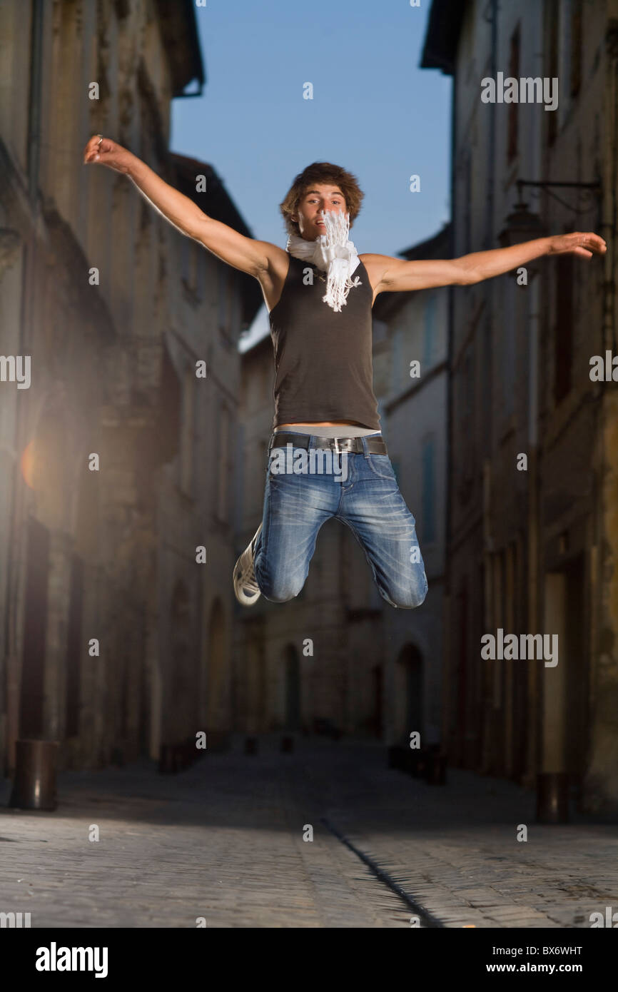 Young man jumps in street at dusk Stock Photo - Alamy