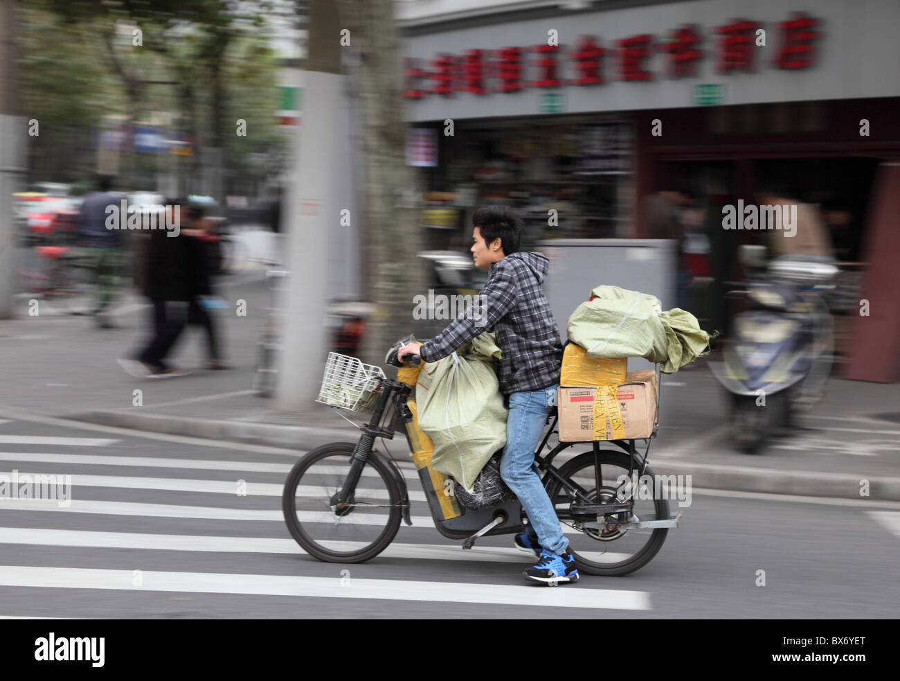 Cyclist in the street of Shanghai, China Stock Photo - Alamy