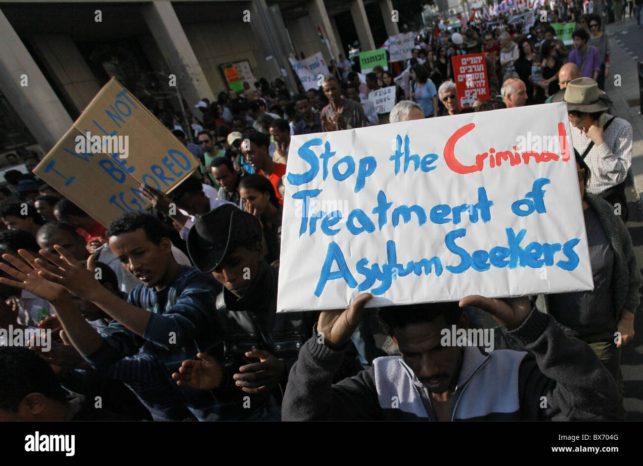 A protester holds up a sign which reads" Stop the criminal treatment of ...