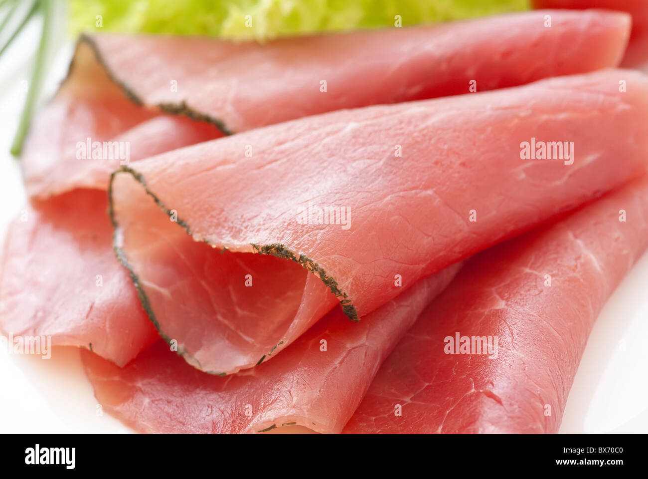 Rolled fillet of ham as closeup on a white plate Stock Photo - Alamy