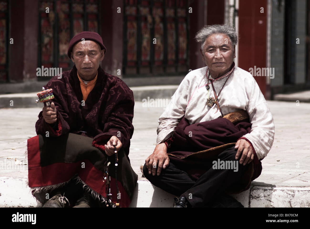 two tibetan men, one with prayer wheel and chain,garze,sichuan,china ...