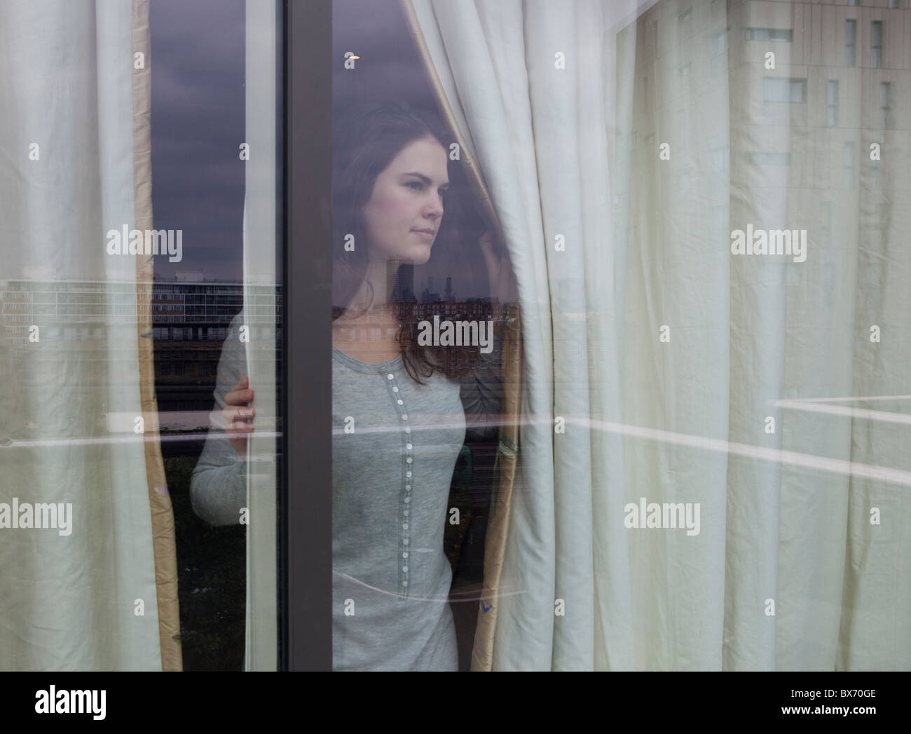 Woman looking out of window Stock Photo - Alamy