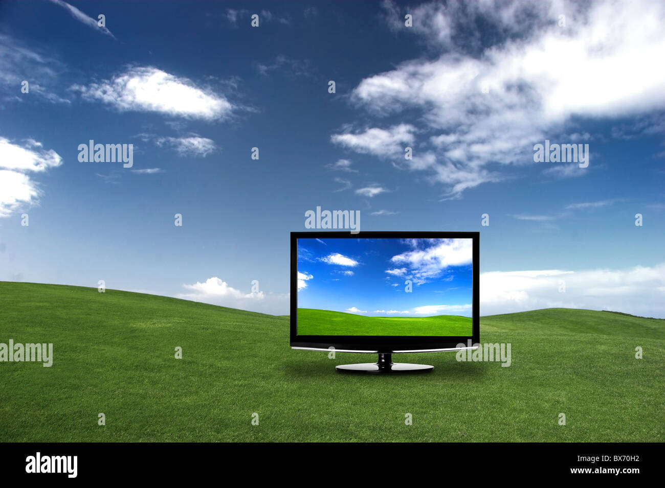 Modern television on a green meadow, showing the colors more beautiful ...