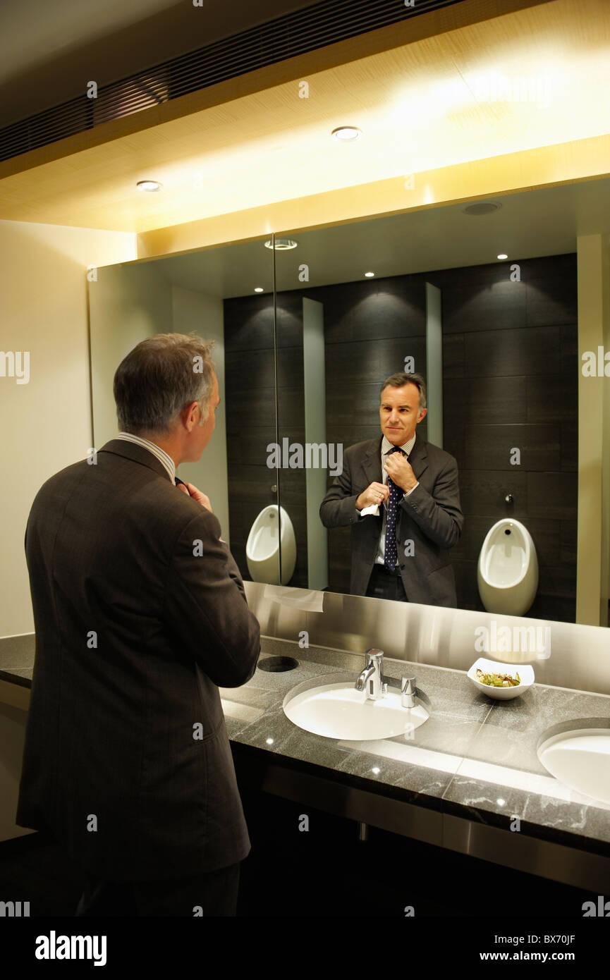 Confident businessman in front of mirror restroom/public toilet Stock ...