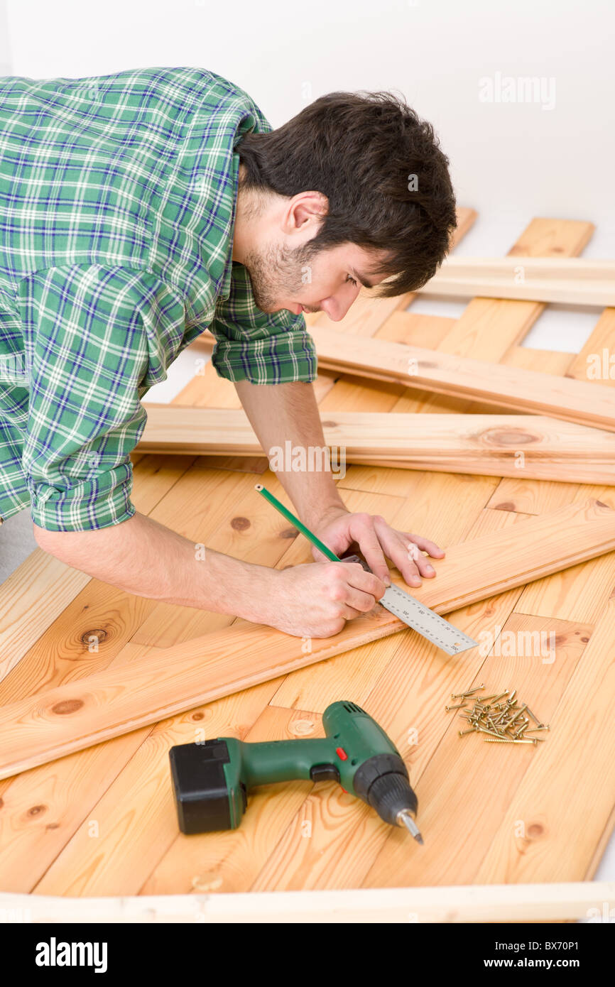 Home improvement - handyman installing wooden floor Stock Photo - Alamy