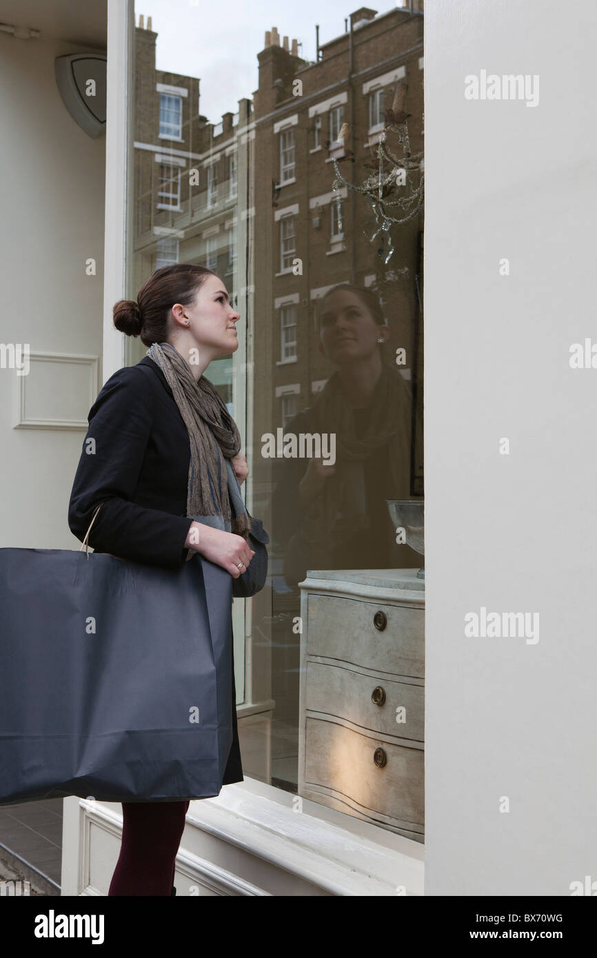 Woman looking in shop window Stock Photo - Alamy