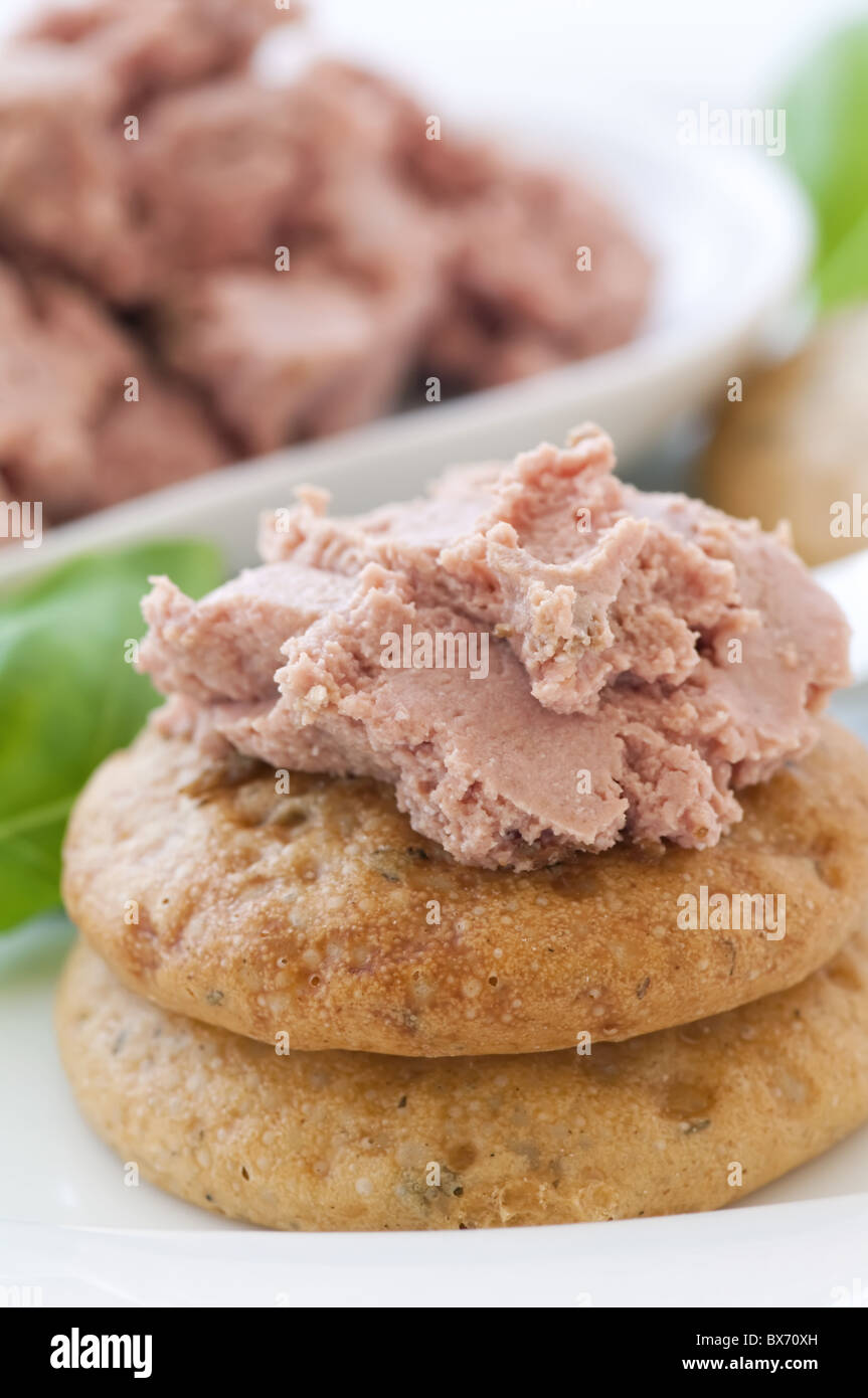 Meat paste with cracker as closeup on white background Stock Photo - Alamy