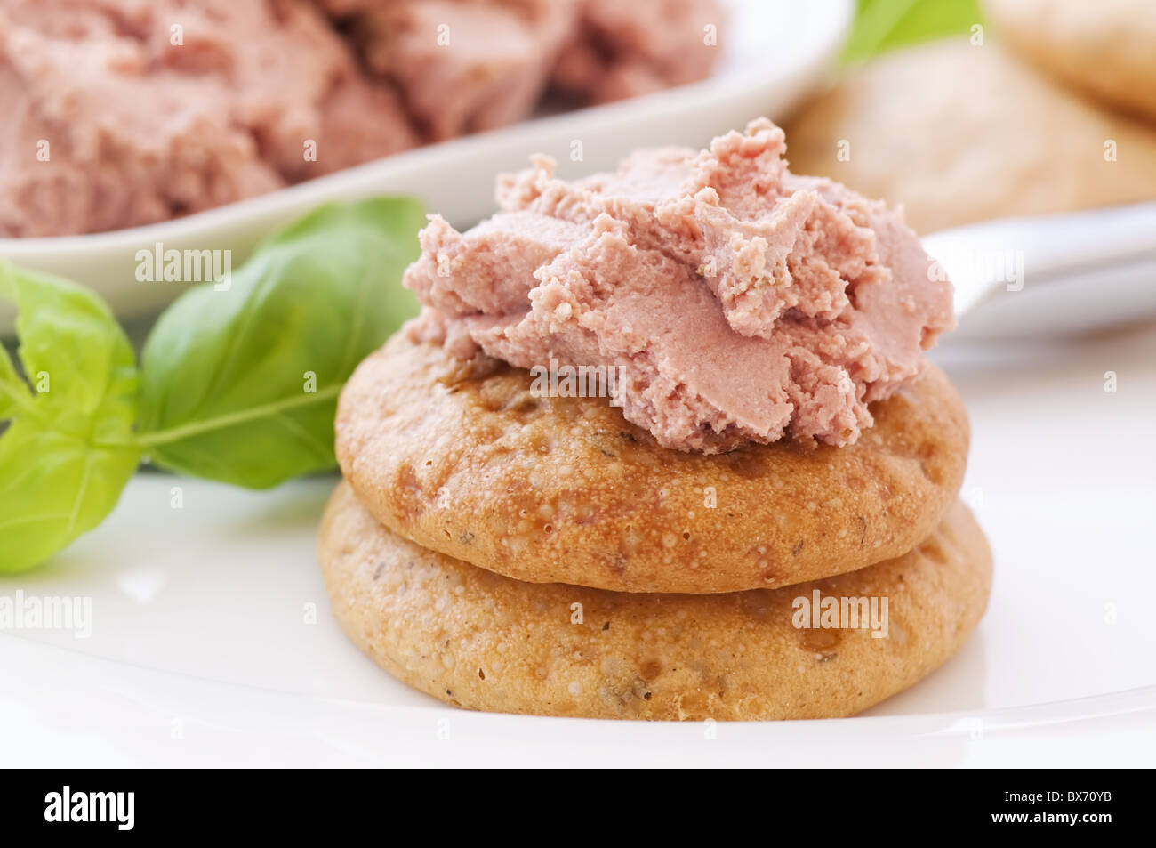 Meat paste with cracker as closeup on white background Stock Photo - Alamy