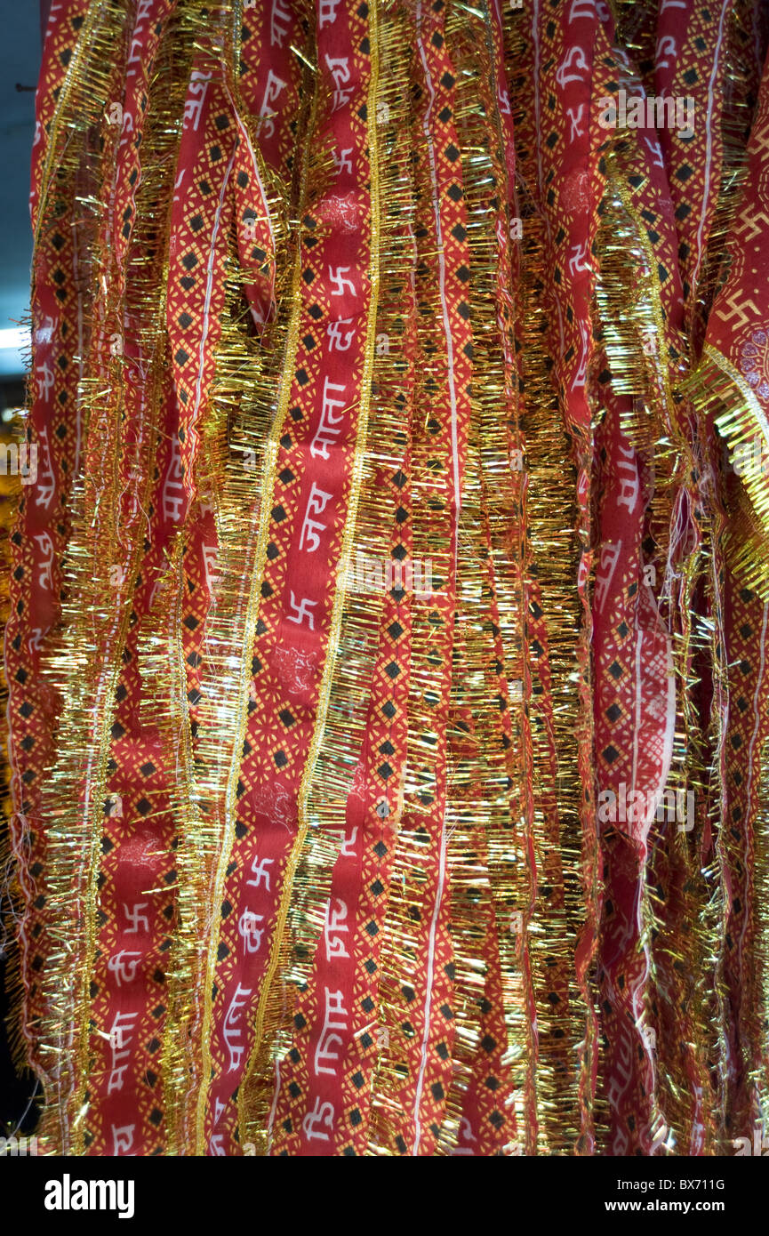 Red and gold tinselled cloths for Hindu devotees visiting a temple ...
